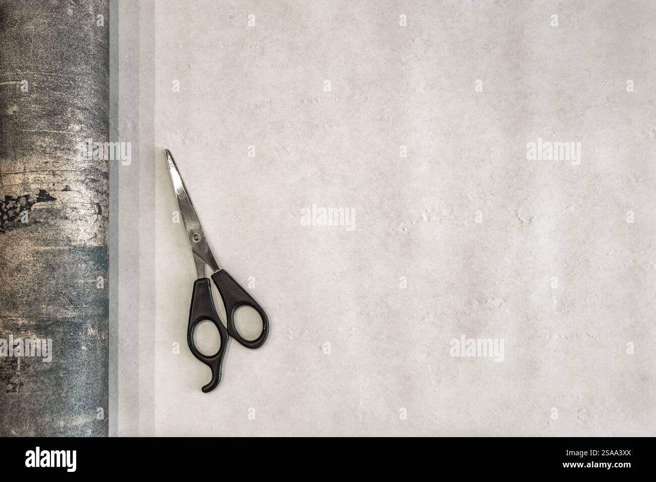 Cutting wallpaper before sticking it to the wall, scissors, measuring tape and pencil on the ...