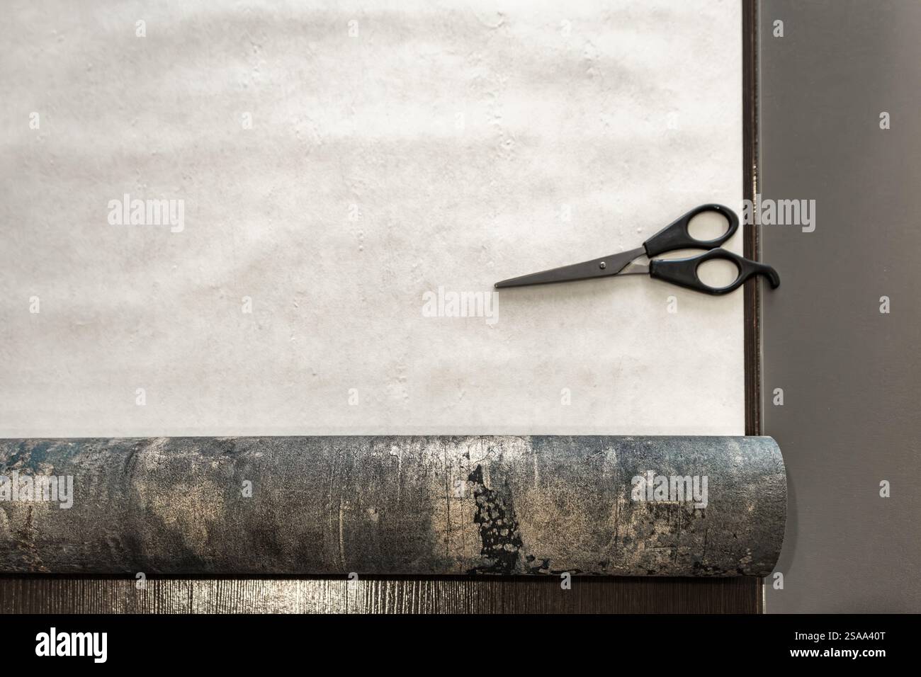 Cutting wallpaper before sticking it to the wall, scissors, measuring ...