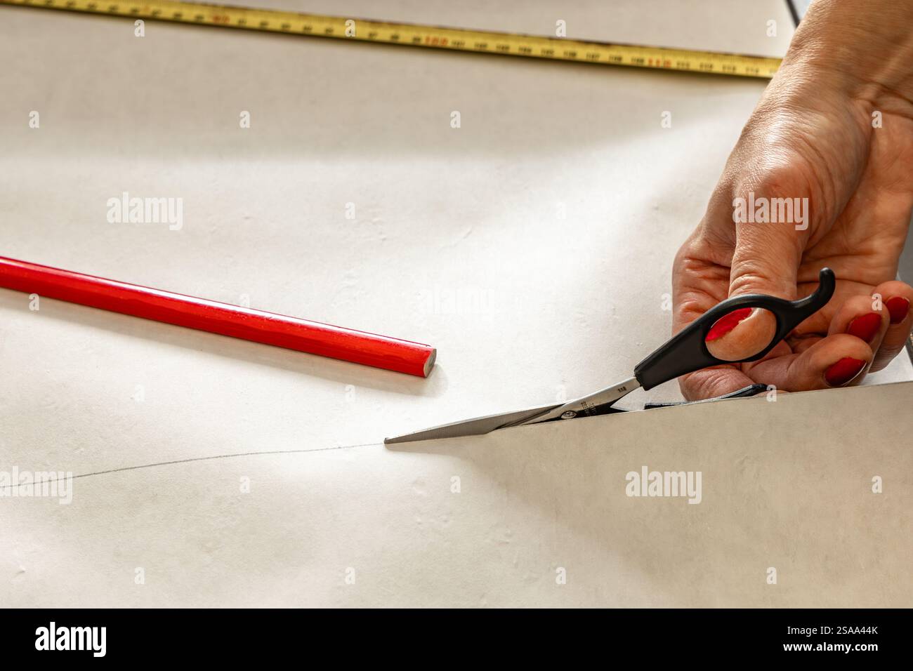 Cutting wallpaper before sticking it to the wall, scissors, measuring ...