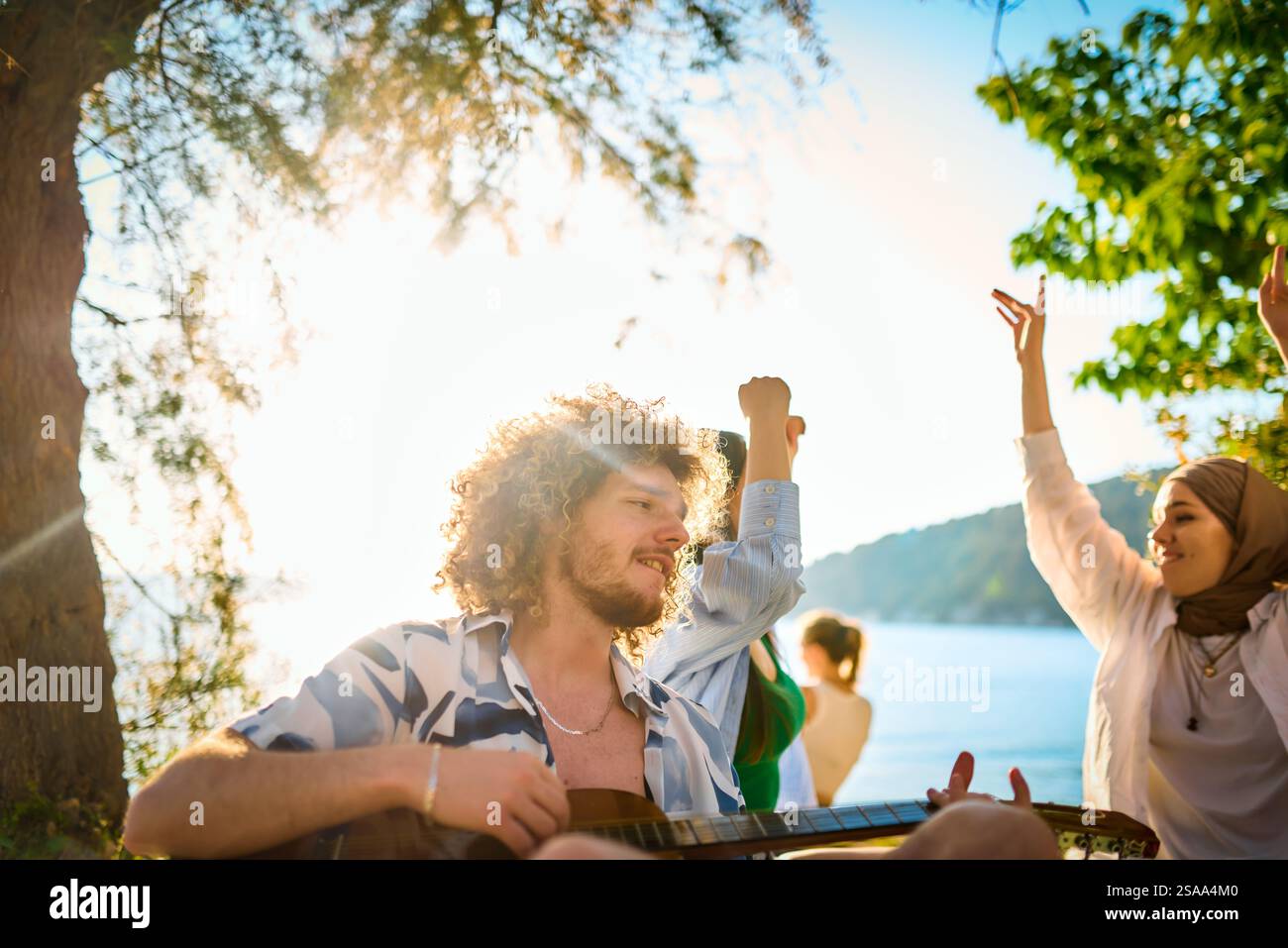 A group of friends gather on the beach sharing joyful moments filled ...