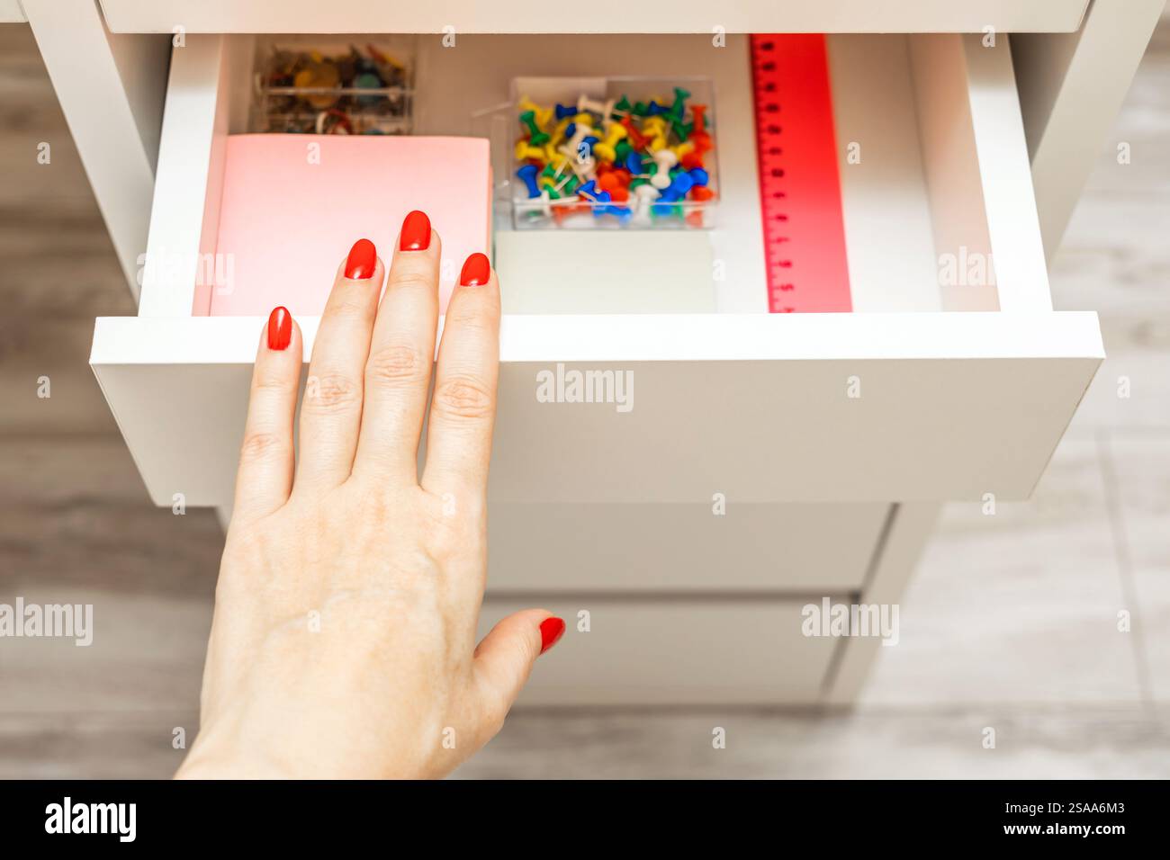 female hand opens desk drawer with office supplies. woman opens office ...