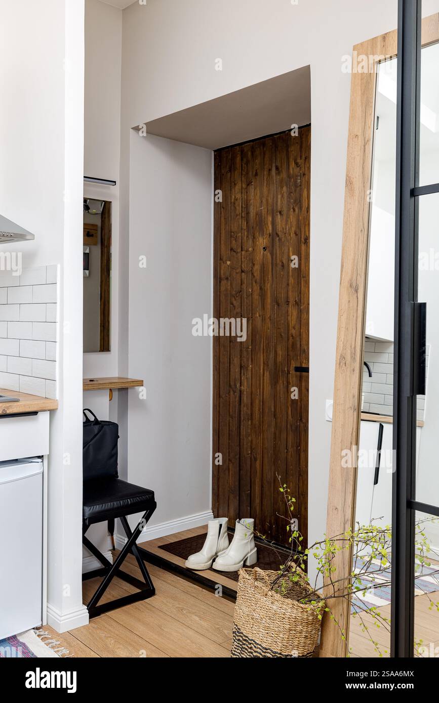 A modern entryway featuring a wood accent combined with a minimalist ...