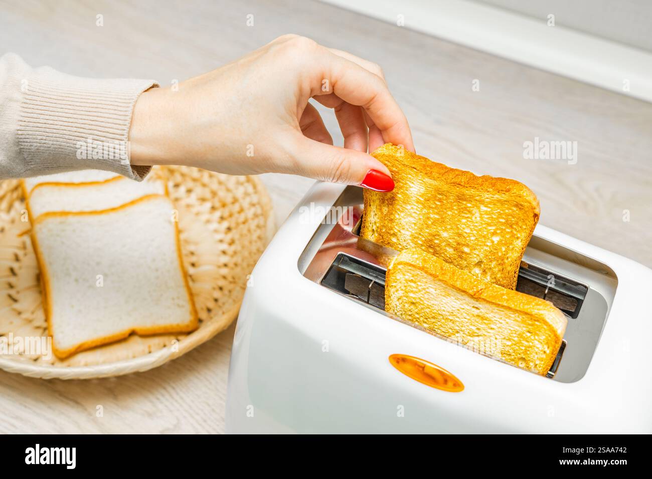 woman hand takes fried toast out of toaster, close-up. woman takes ...