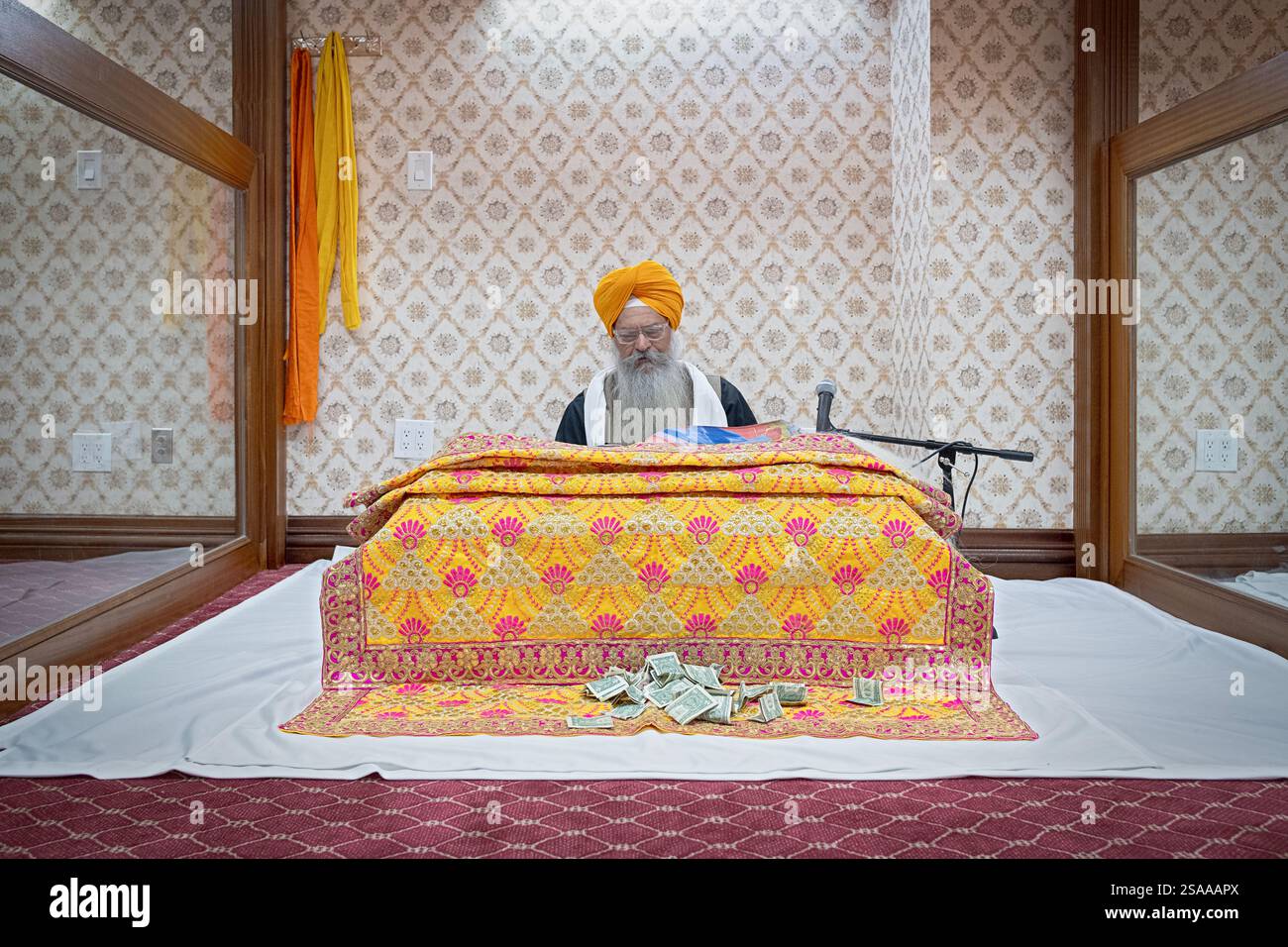A Sikh priest reads his bible at an Akhand Path service where the ...