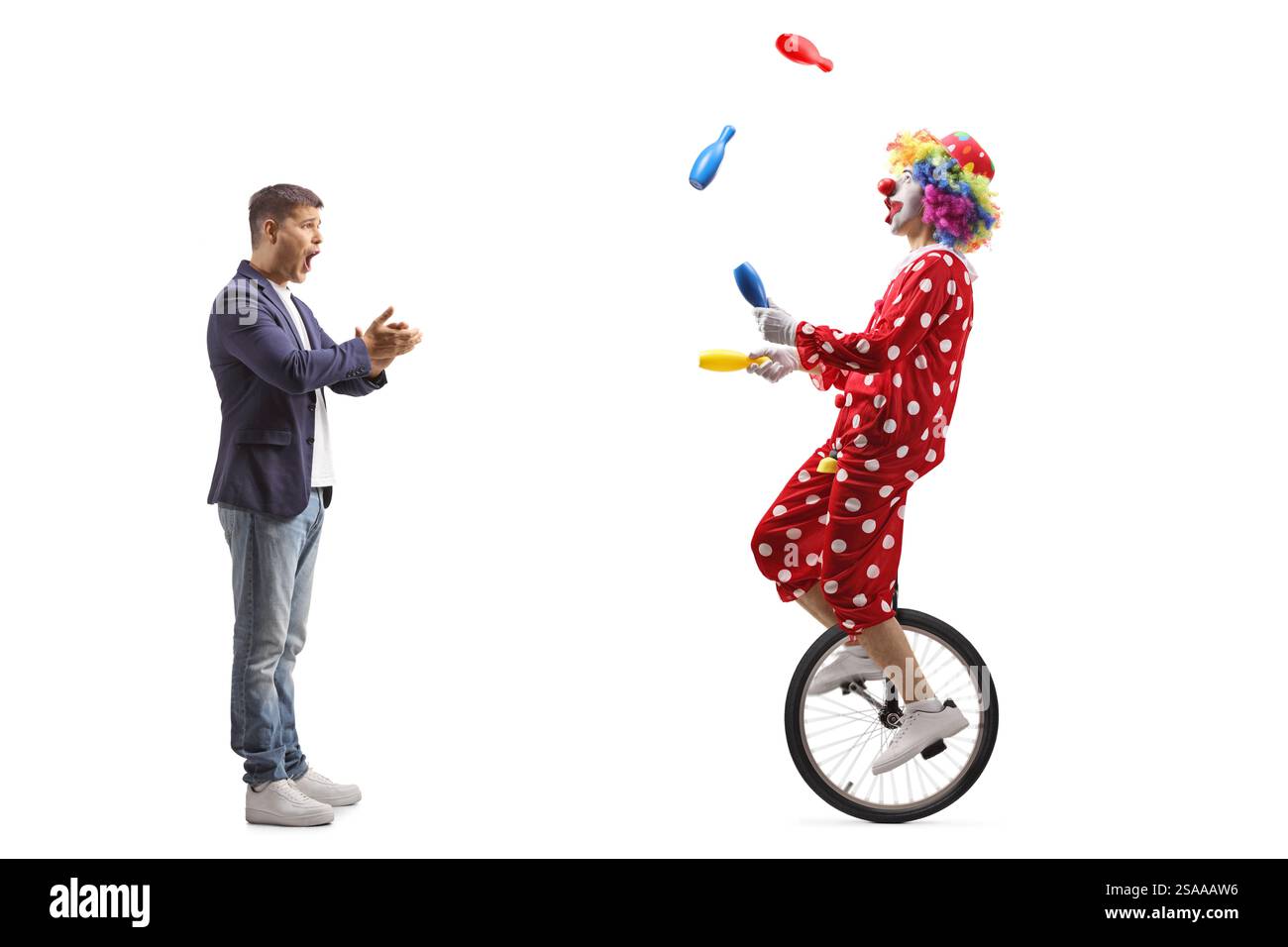 Amazed man clapping and watching a clown juggling on a mono cycle ...