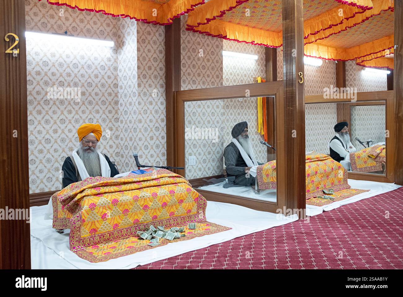 3 Sikh priests read their bibles at an Akhand Path service where the ...