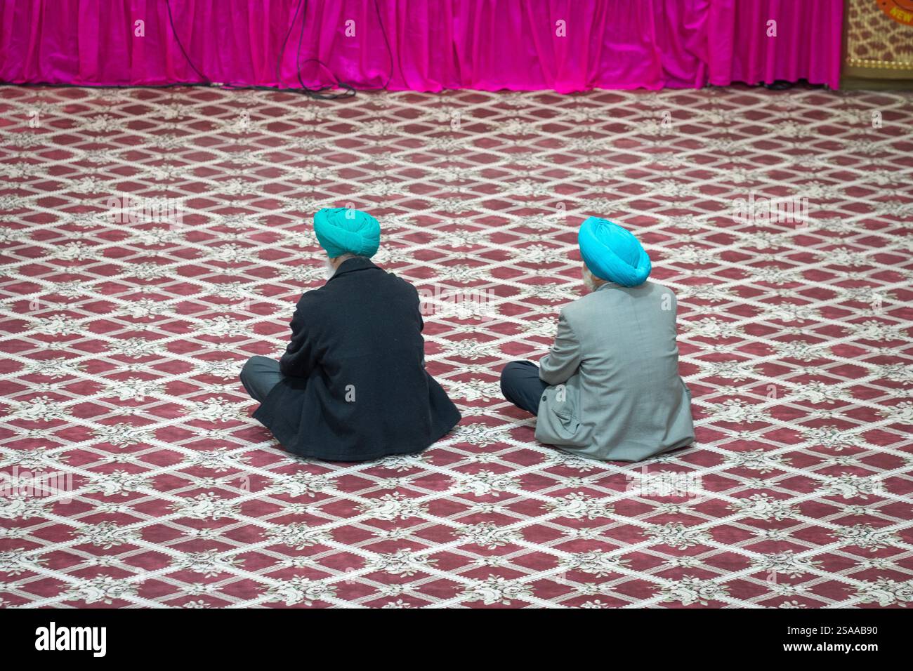 2 older Sikh men wearing almost identical turbans. At an otherwise ...