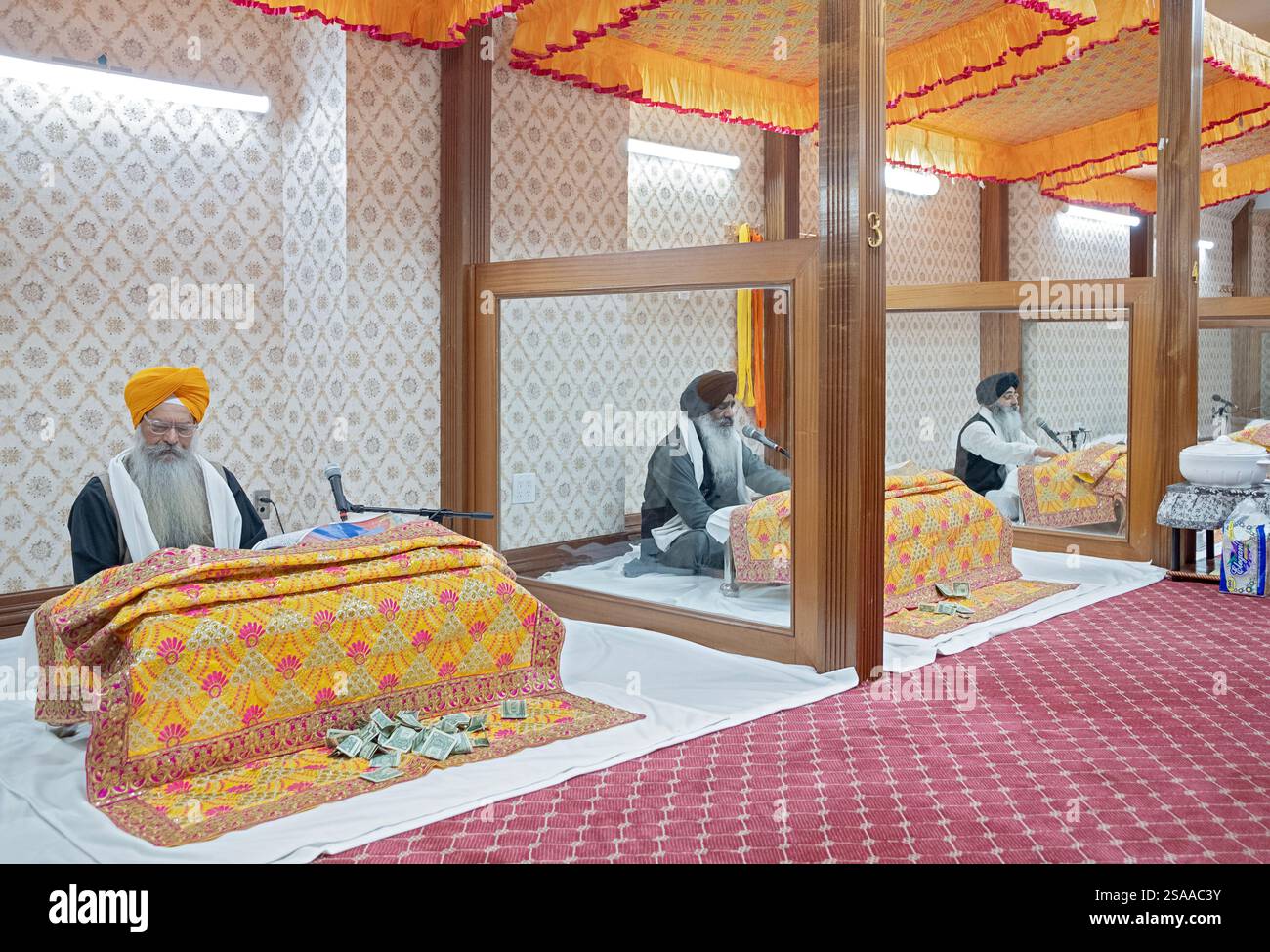 3 Sikh priests read their bibles at an Akhand Path service where the ...