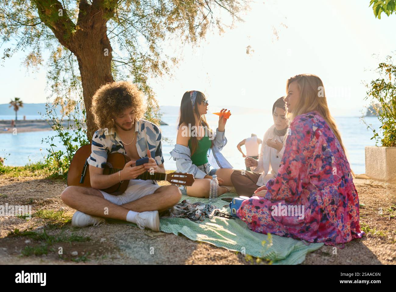 A group of friends gather on the beach sharing joyful moments filled ...