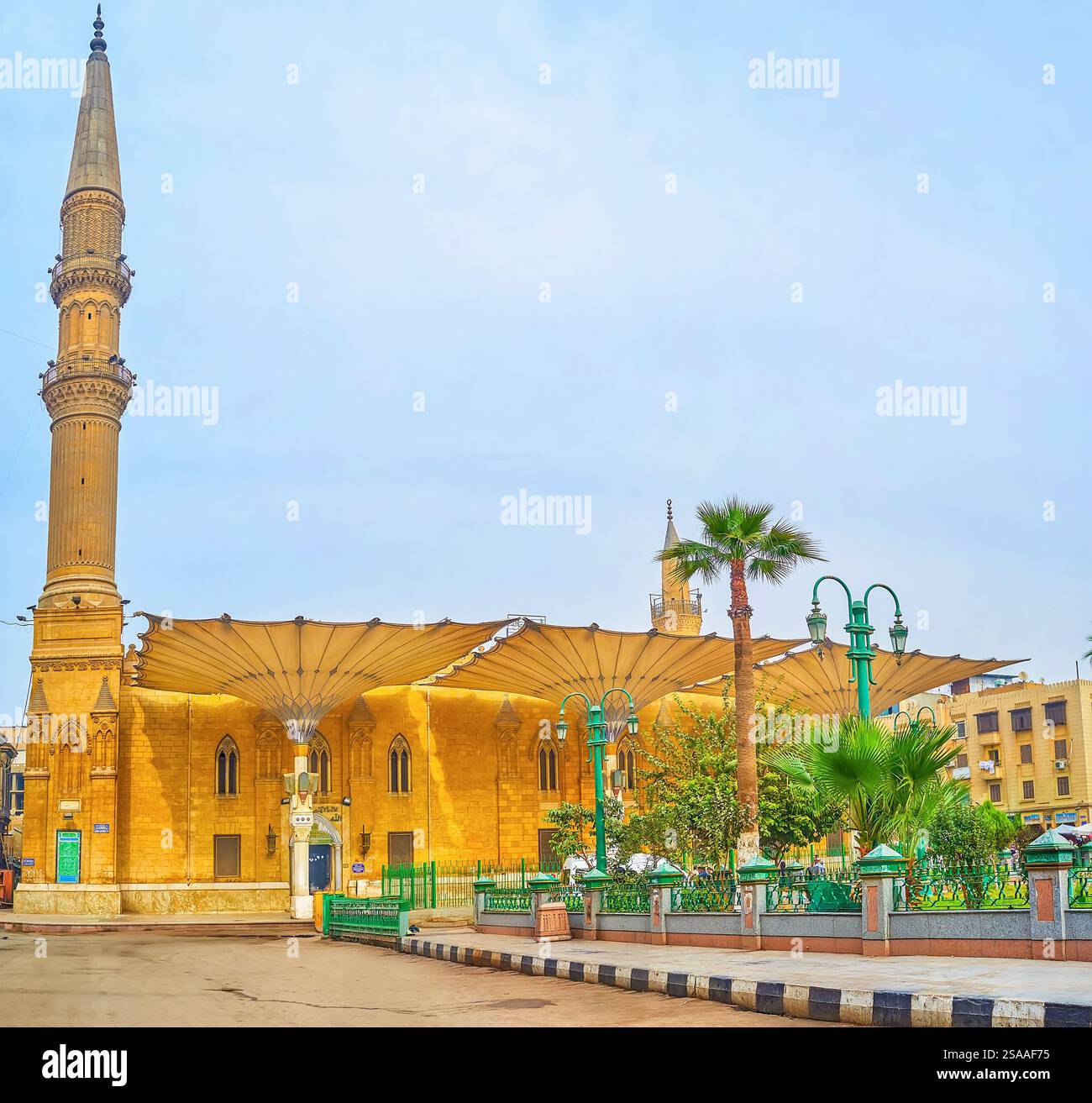 The medieval Al-Hussein Mosque with tall minaret and big umbrellas at ...