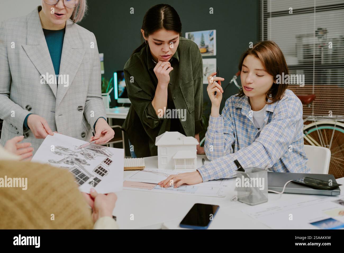 Group of diverse architects collaborating on urban model design in ...