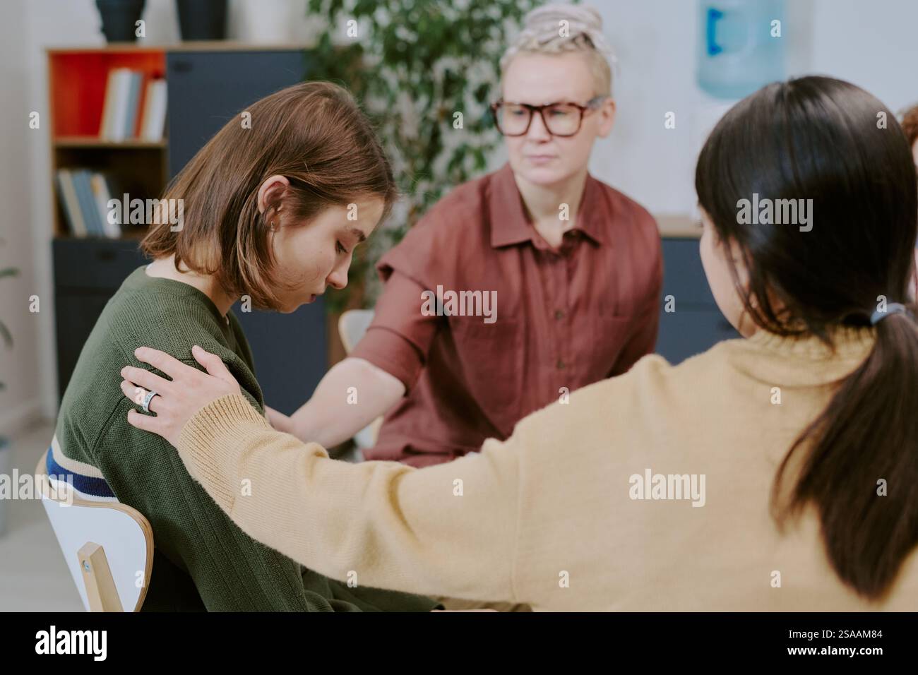 Counselor and two women engaging in supportive therapy session in cozy ...