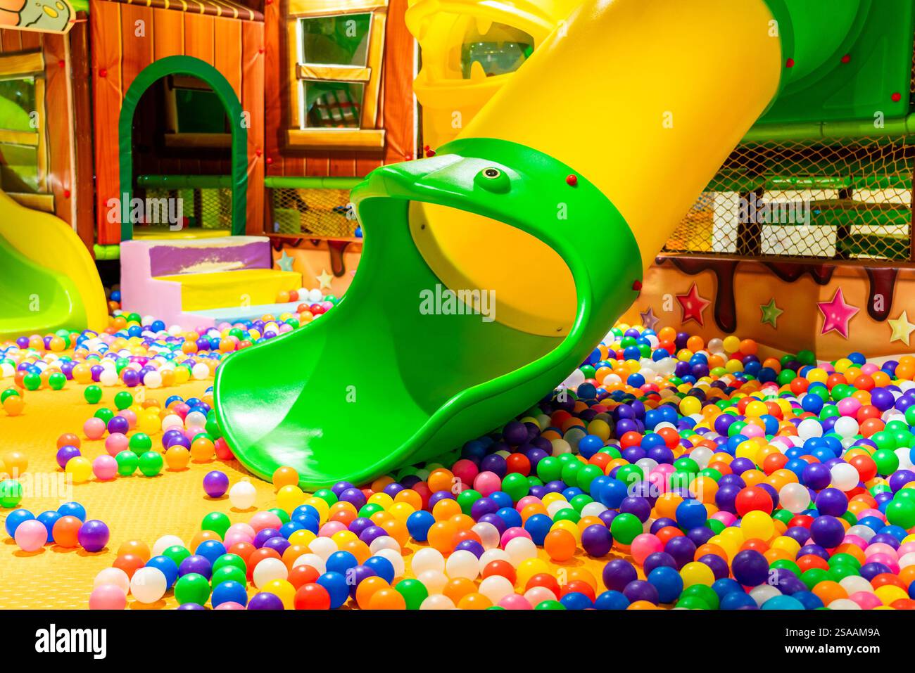 A colorful indoor playground with vibrant slides and a cheerful ball ...