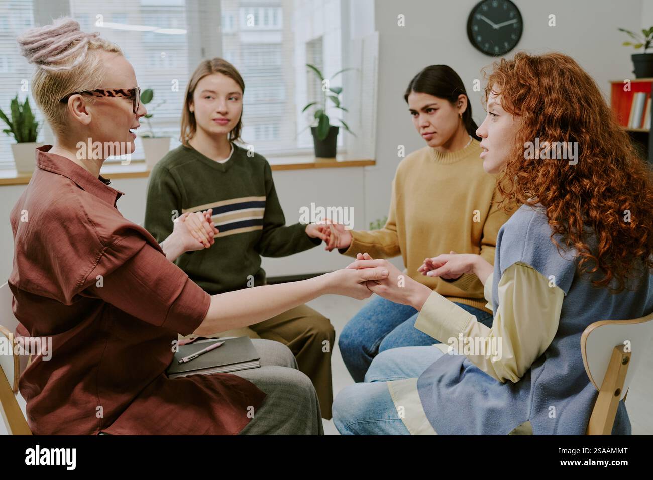 Therapist leading group therapy session with diverse participants ...