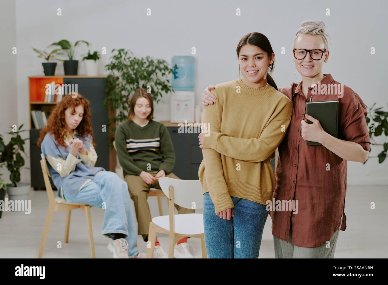 Group of four diverse colleagues relaxing in a cozy office space ...