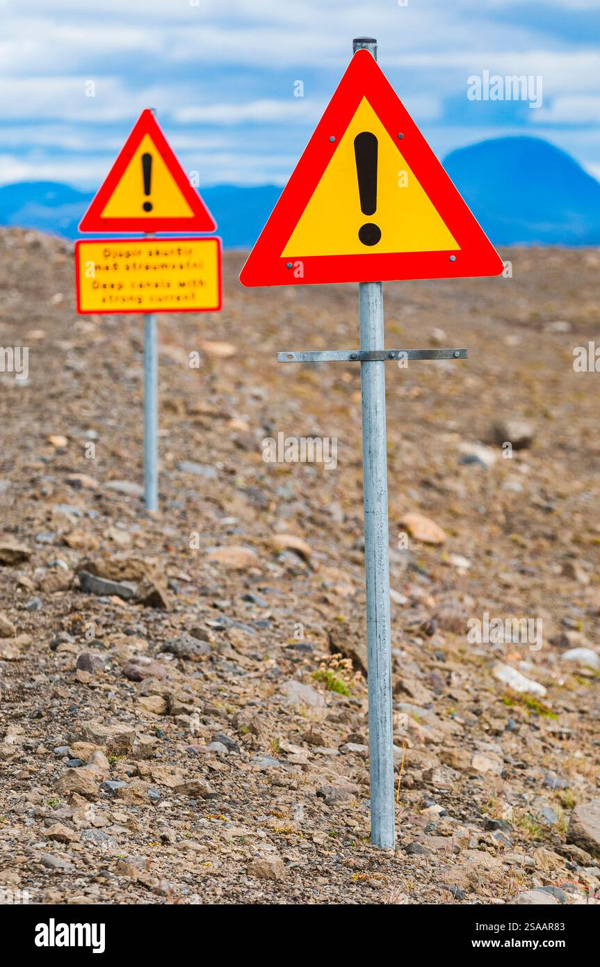 Two triangular warning signs with exclamation marks stand prominently ...