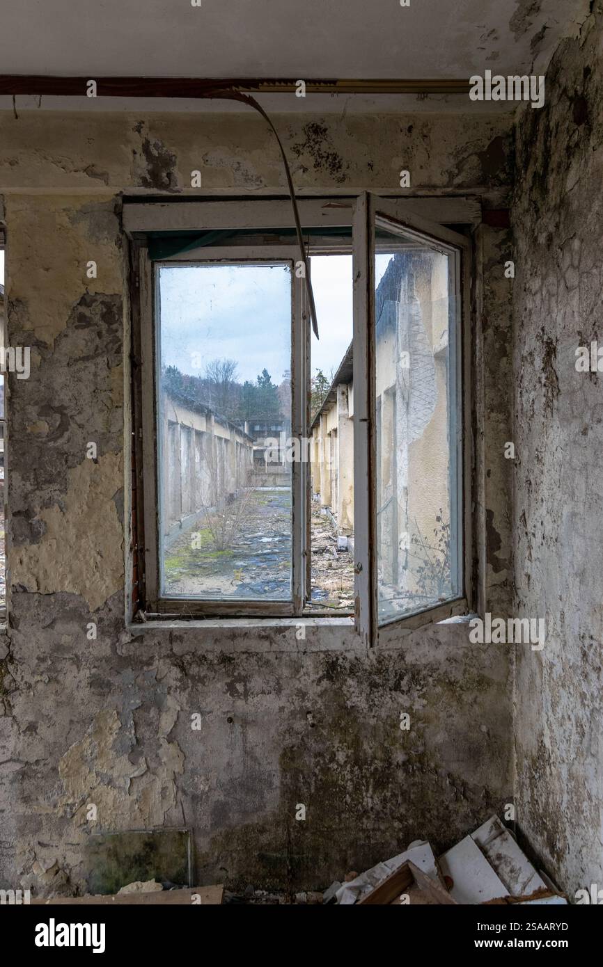 A look through a window of an old looted factory falling apart ...