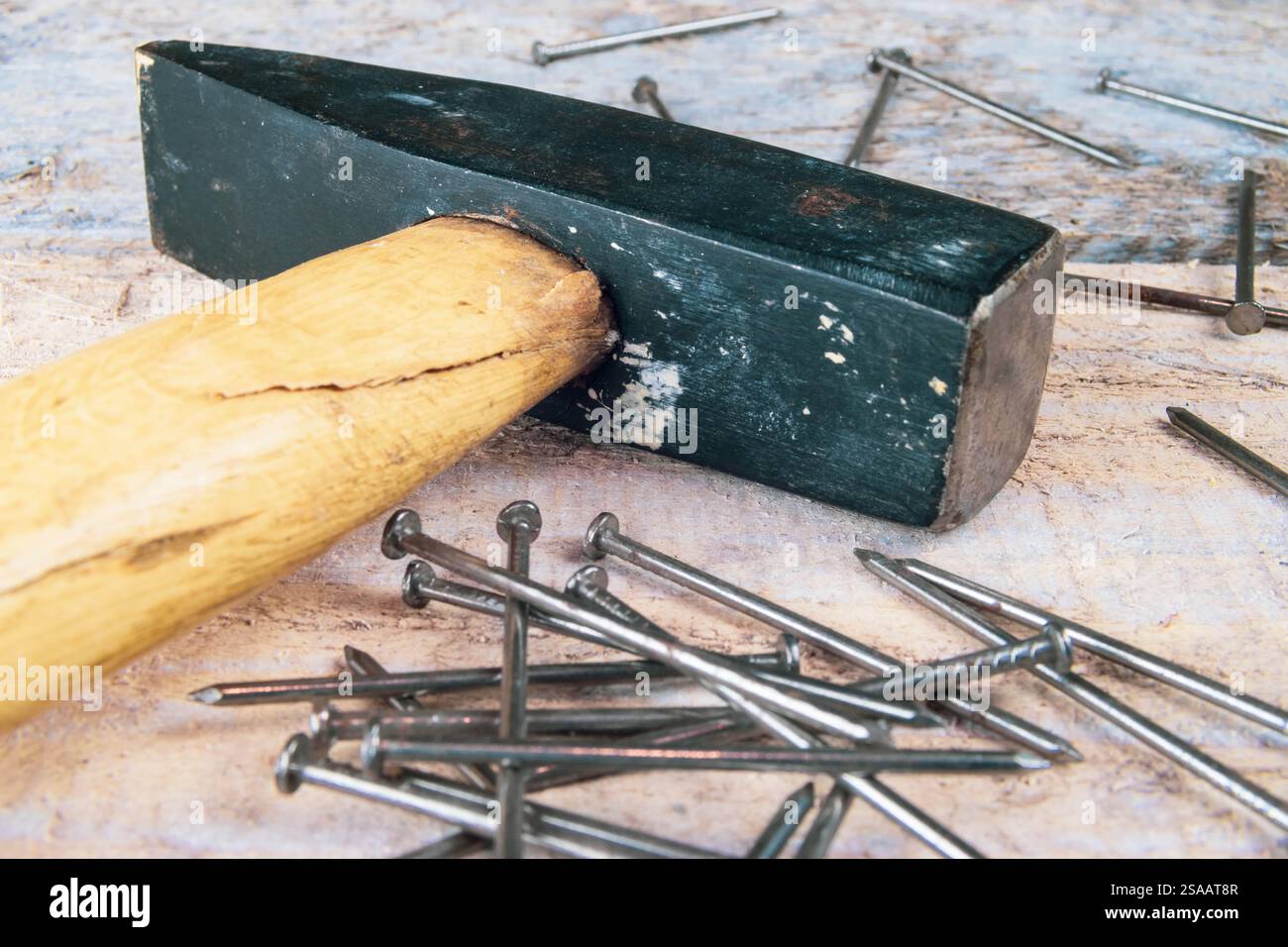 Hammer and a pile of nails on an old wooden table. Laying flat on a ...