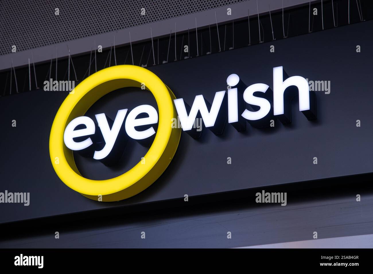 Eye Wish Opticien store, with illuminated shop logo Stock Photo - Alamy