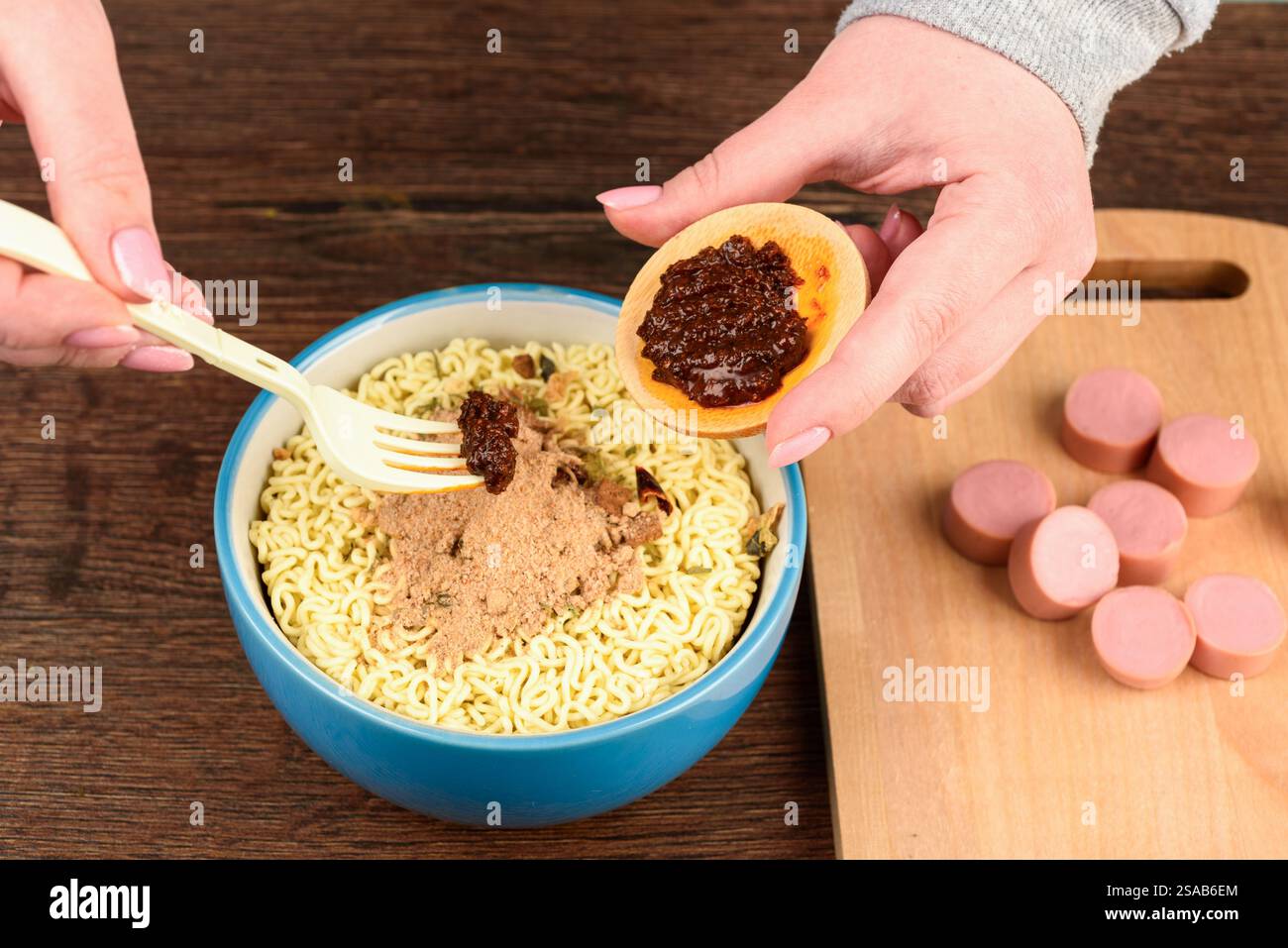 Adding sauce and soup dressing to instant noodles. Fast food Stock ...