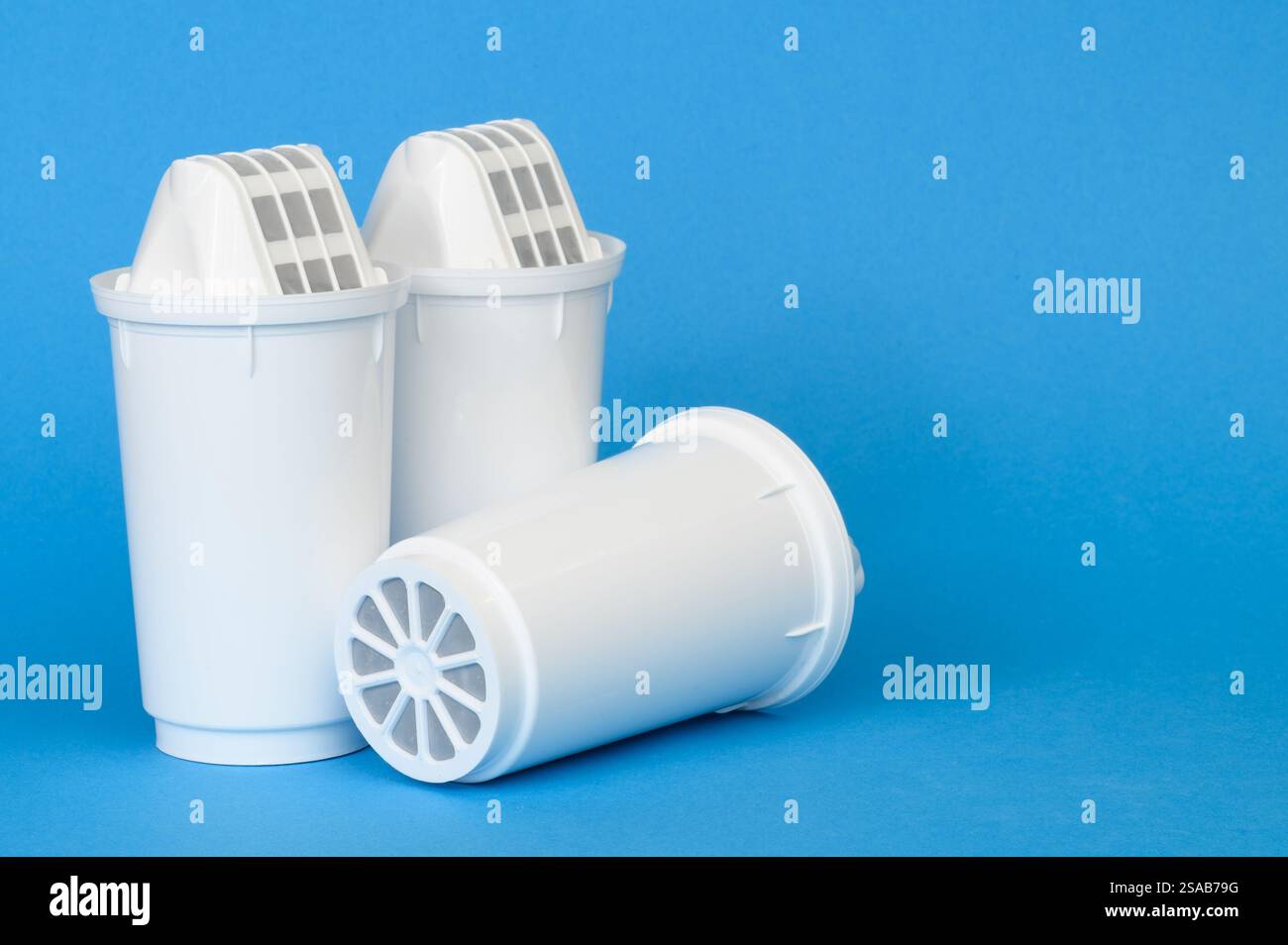 Three new filter cartridges for water purification on a blue background ...