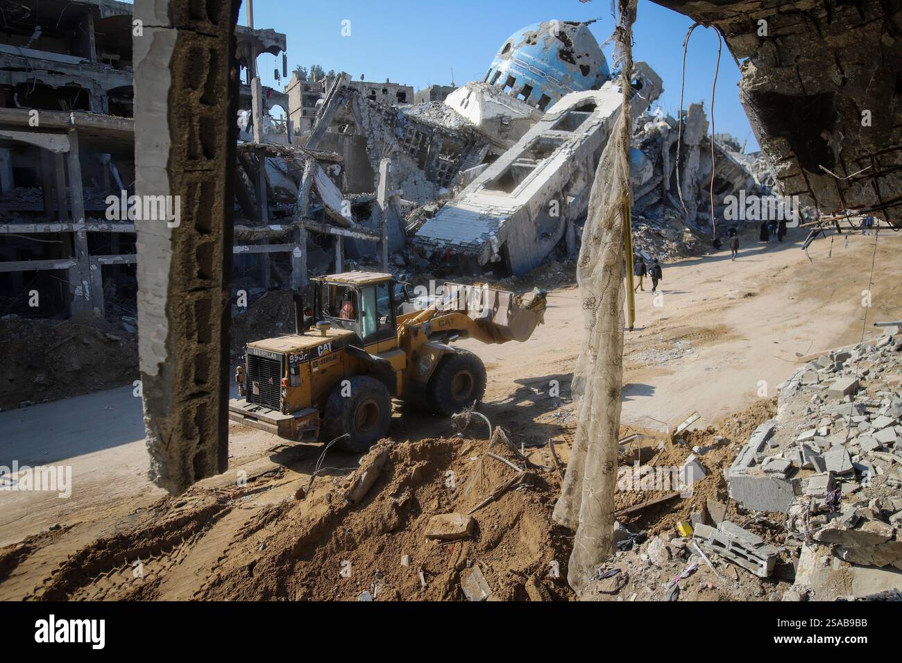 A bulldozer removes the rubble next to a destroyed mosque in Beit Lahia ...