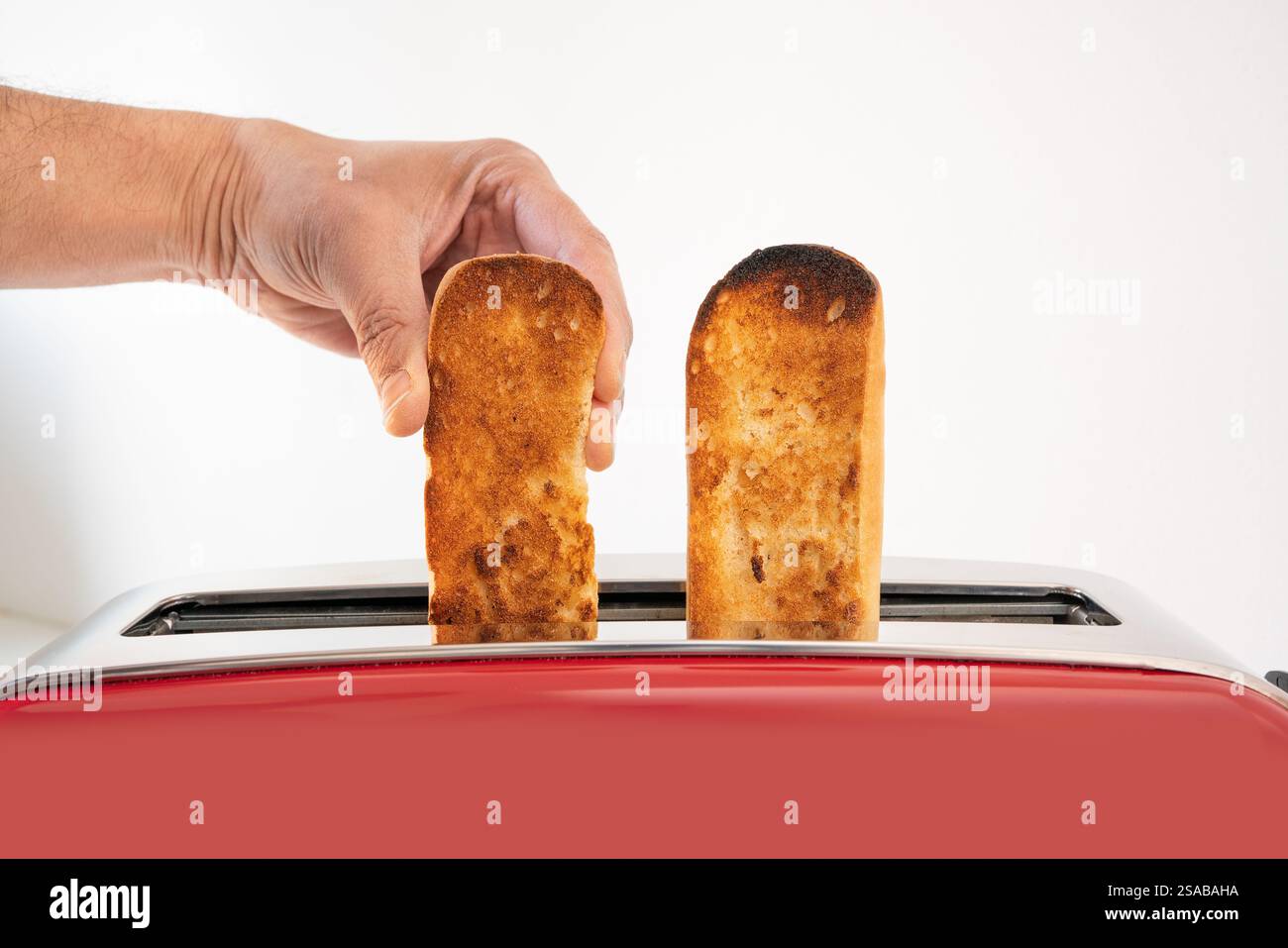 Hand holding a toast burns and smokes in the toaster. Forgetful, late ...