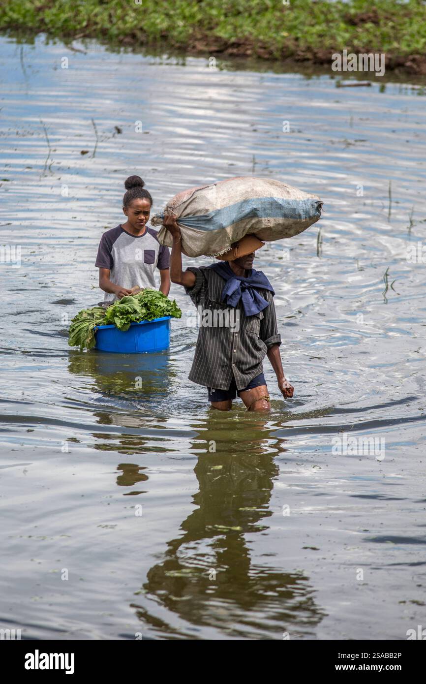 Madagascar rising flood waters Family members wade through the flood ...
