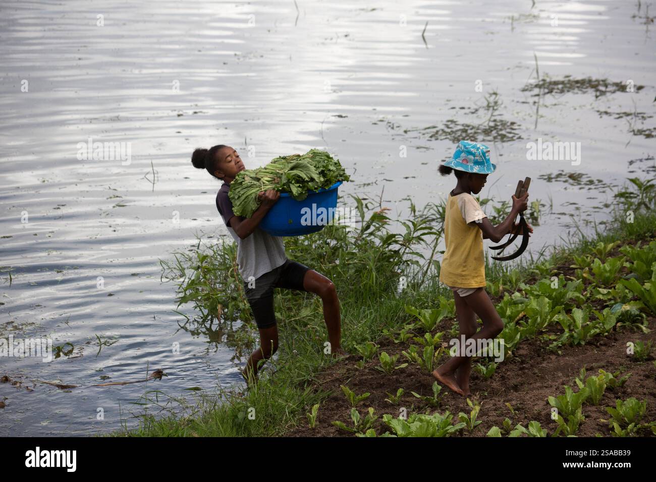 Madagascar rainy season Family members wade through the flood waters to ...