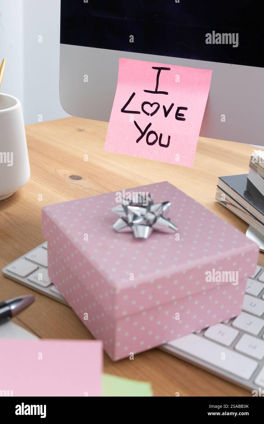 A romantic scene featuring a computer screen with a sticky note that ...