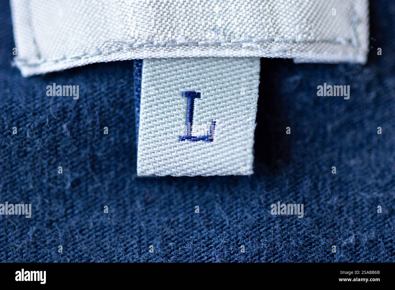 real macro of L size clothing label with blue background Stock Photo ...