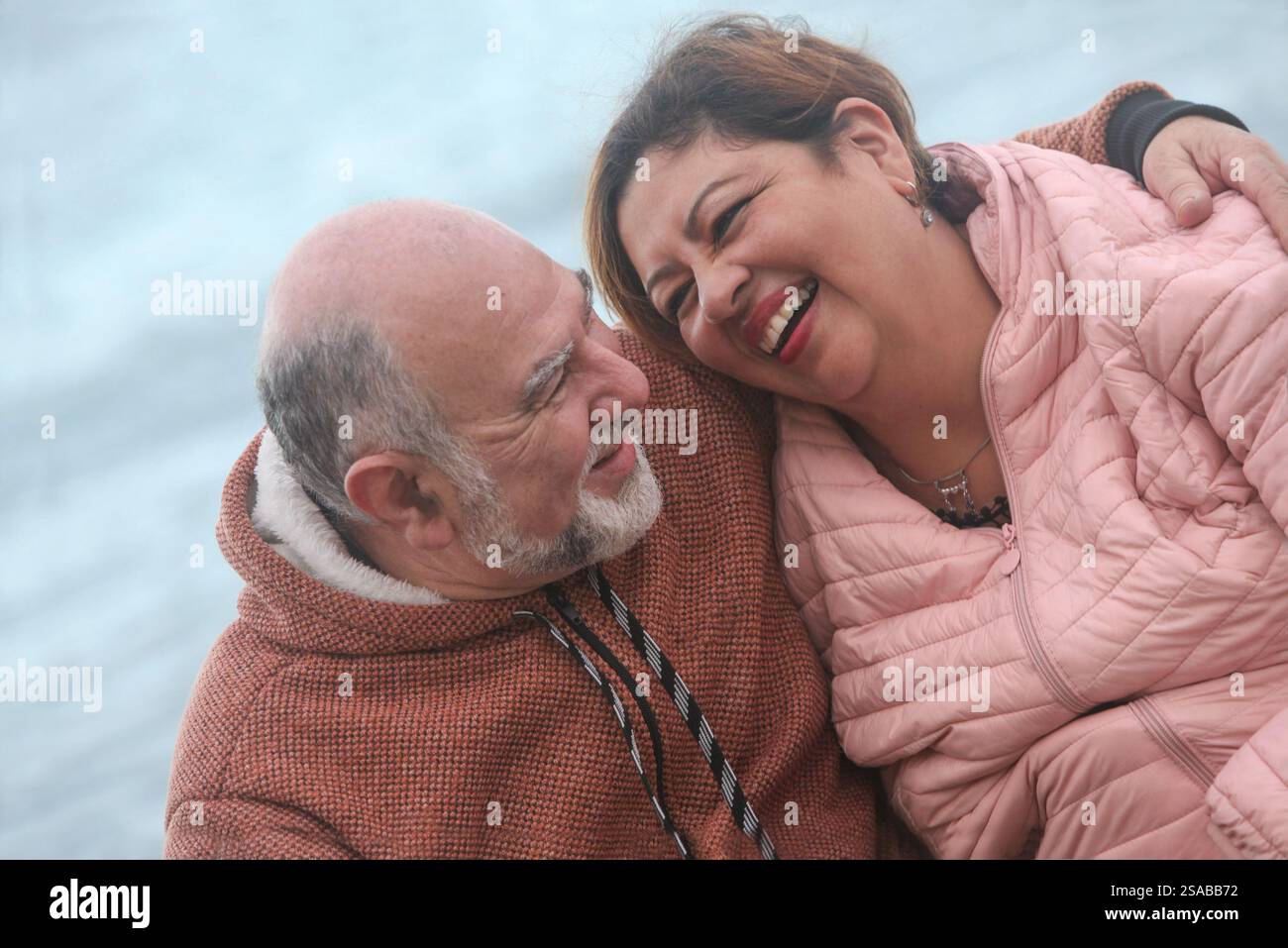 closeup portrait of laughing mature couple outdoors on cloudy cold day ...