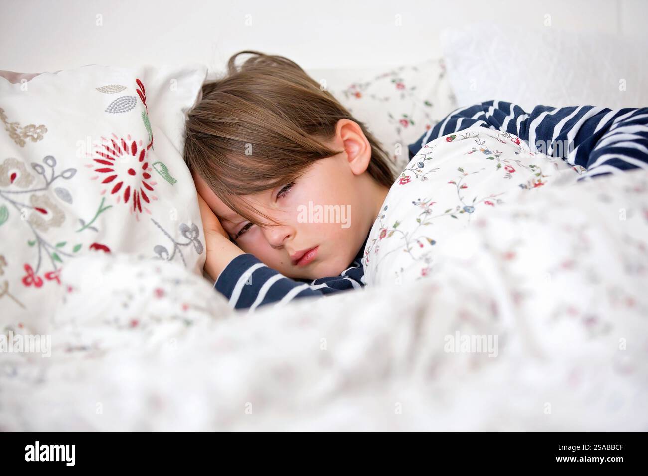 Sick child boy lying in bed with a fever, resting Stock Photo - Alamy