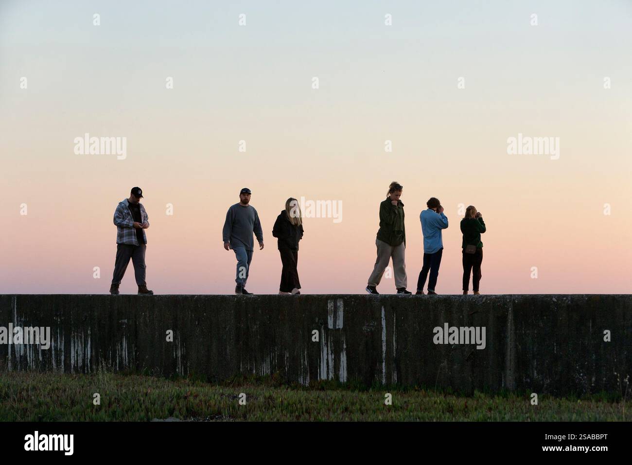 Visitors walking Harbor Jetty (breakwater) at sunset, Crescent City ...
