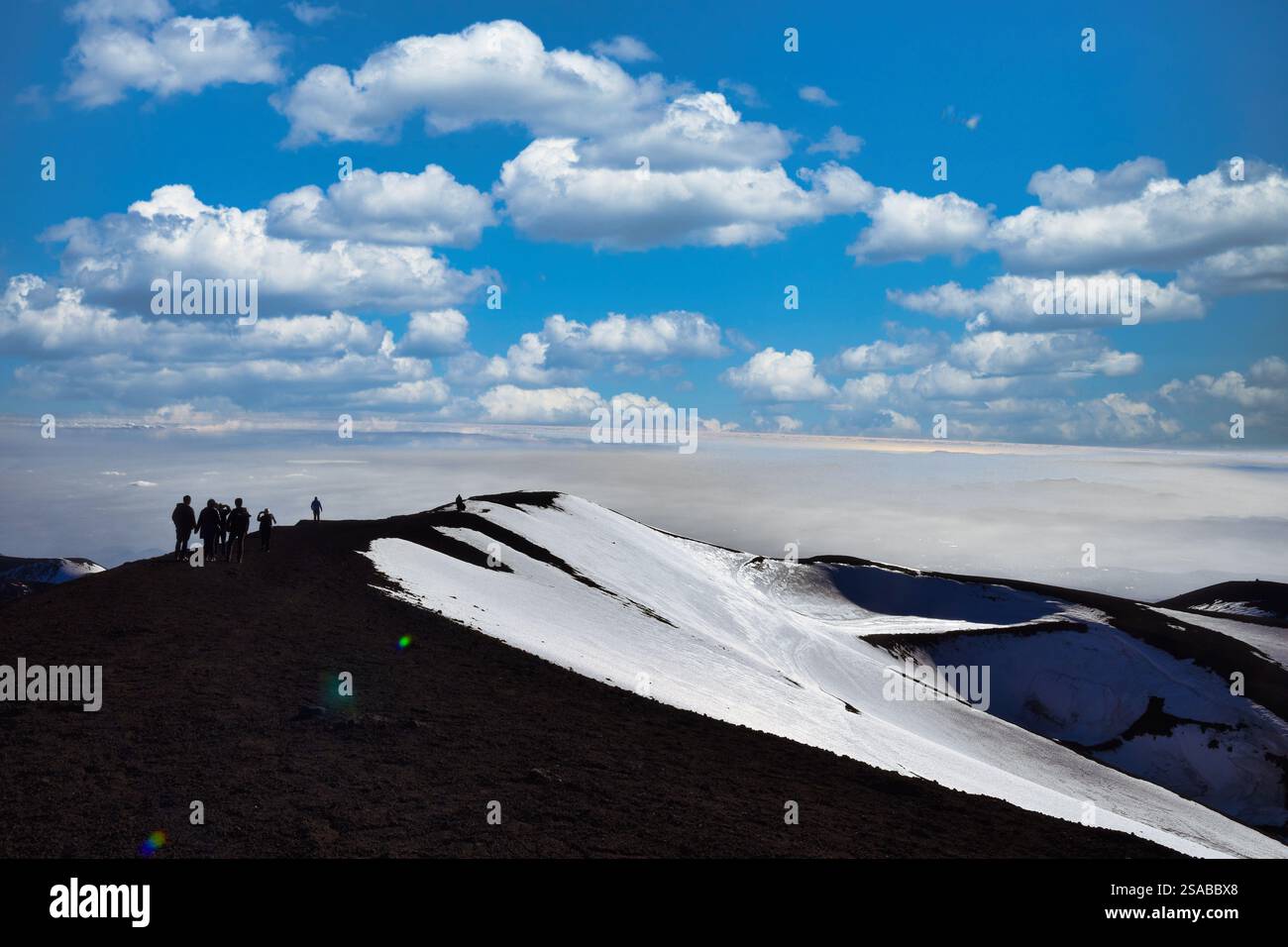 Travelers on the snow-covered Mount Etna in Catania (Sicily) in Italy ...
