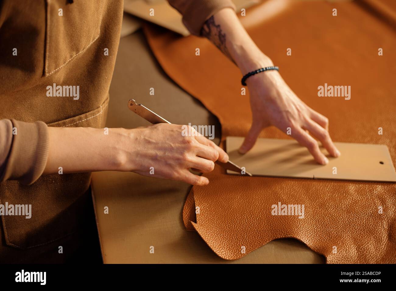Close-up of hands skillfully cutting leather with a blade, showing ...