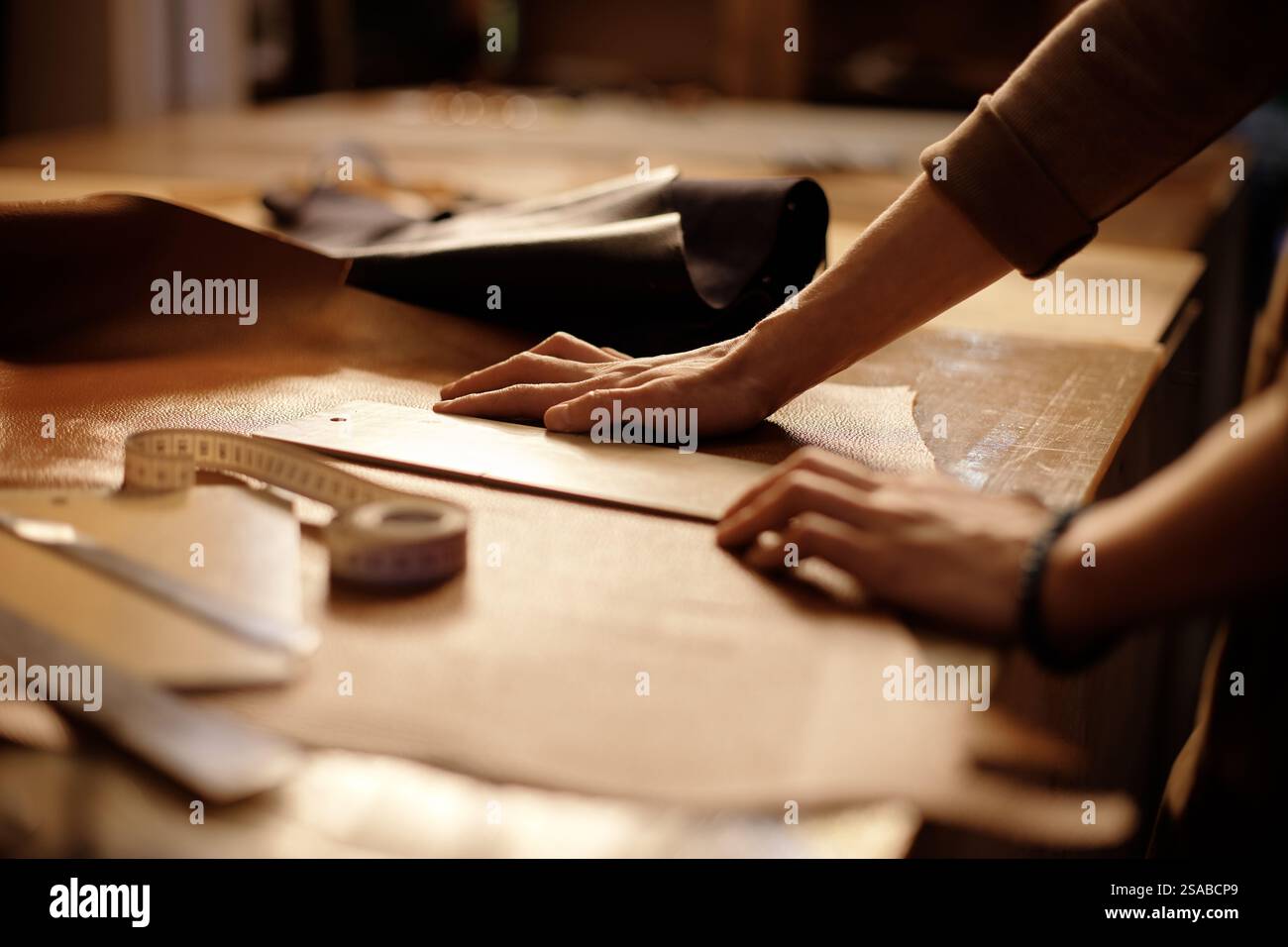 Person carefully working on leather crafts with precision equipment on ...