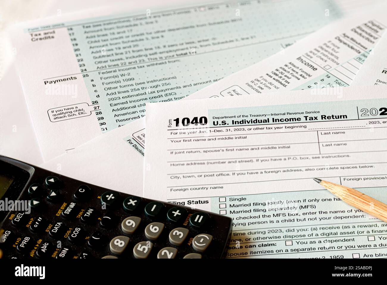 IRS 1040 tax form with calculator and pencil on a table. Tax time USA ...