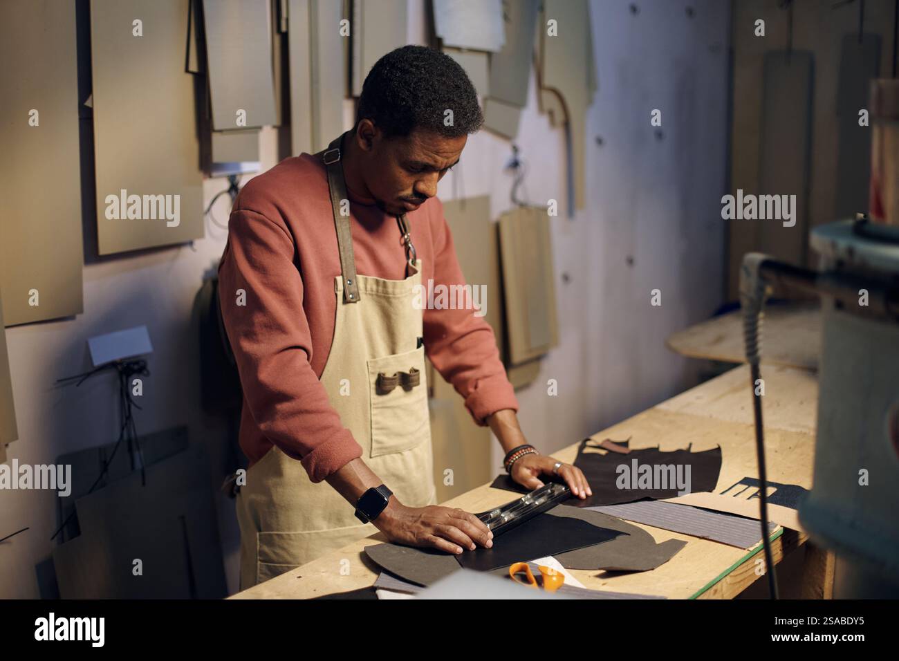 Professional leatherworker meticulously cutting leather pieces using a ...