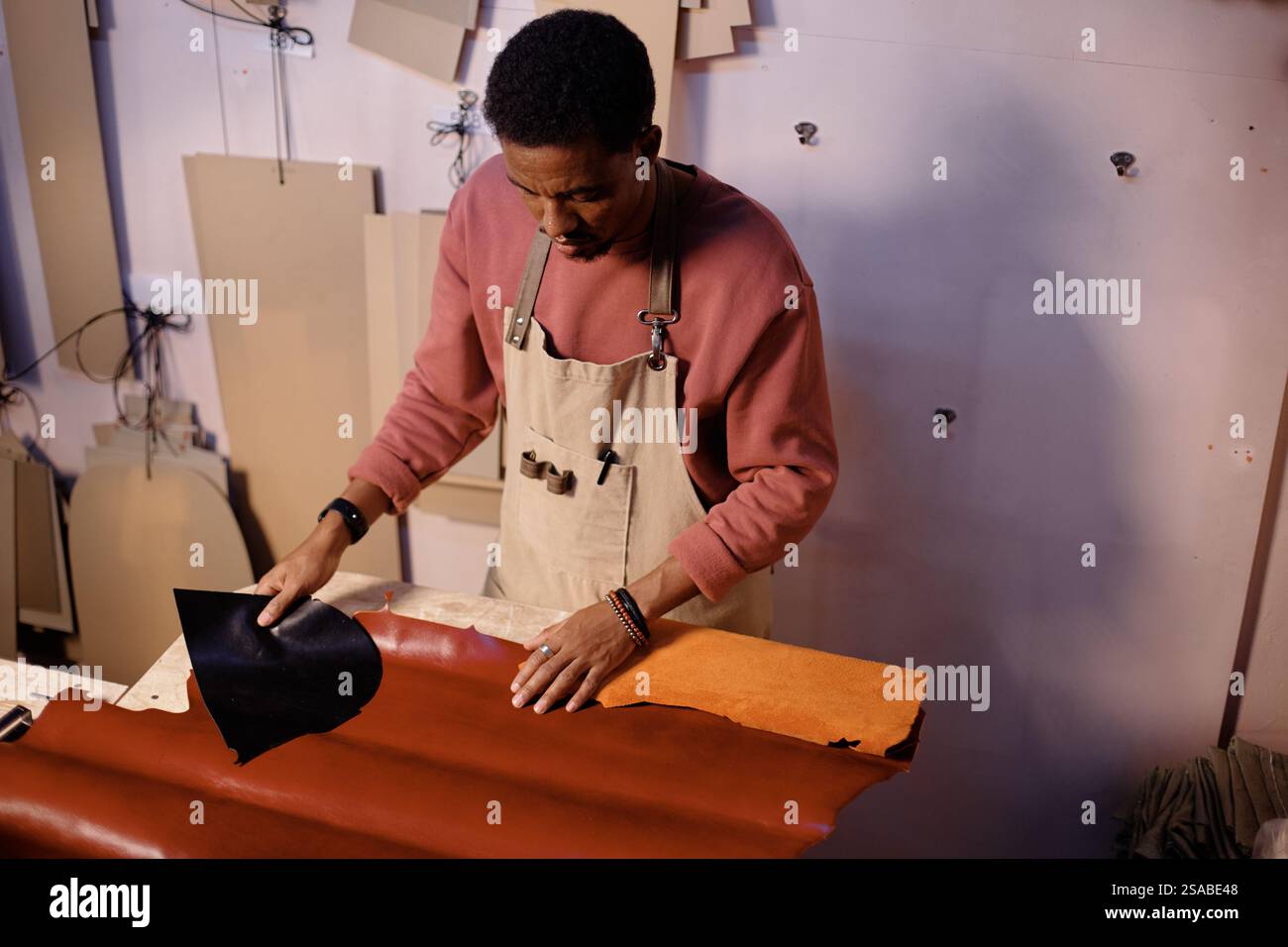 Artisan creating quality leather goods in a well-organized workshop ...