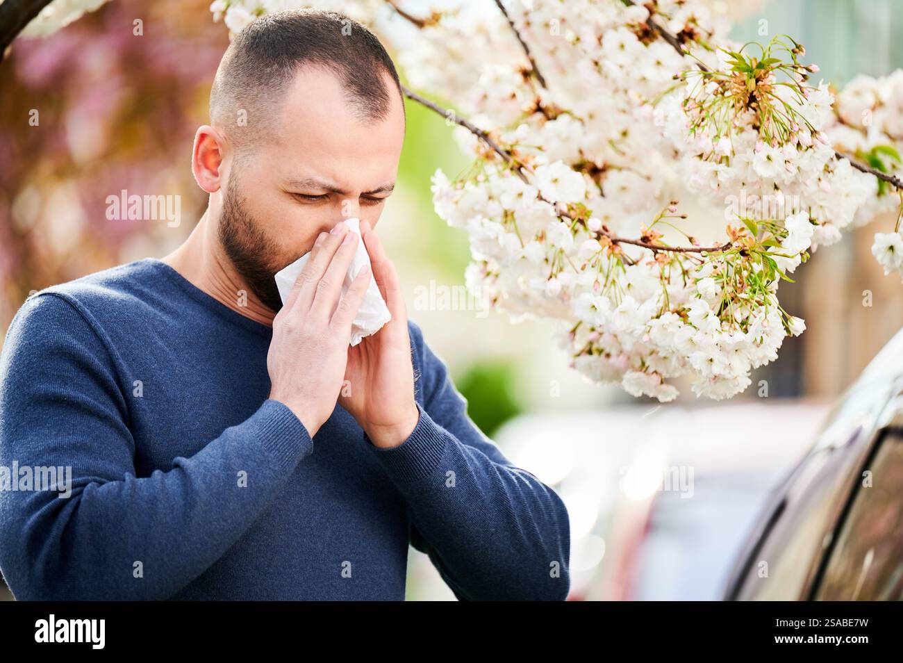 Man allergic suffering from seasonal allergy at spring in blossoming ...