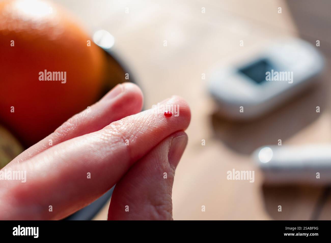 Woman pricking her finger to check blood glucose level with glucometer ...