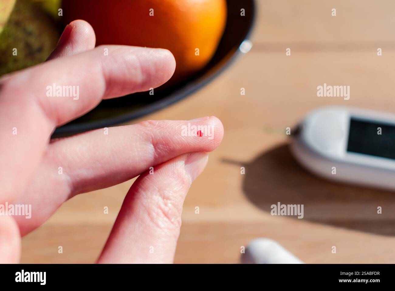 Woman pricking her finger to check blood glucose level with glucometer ...