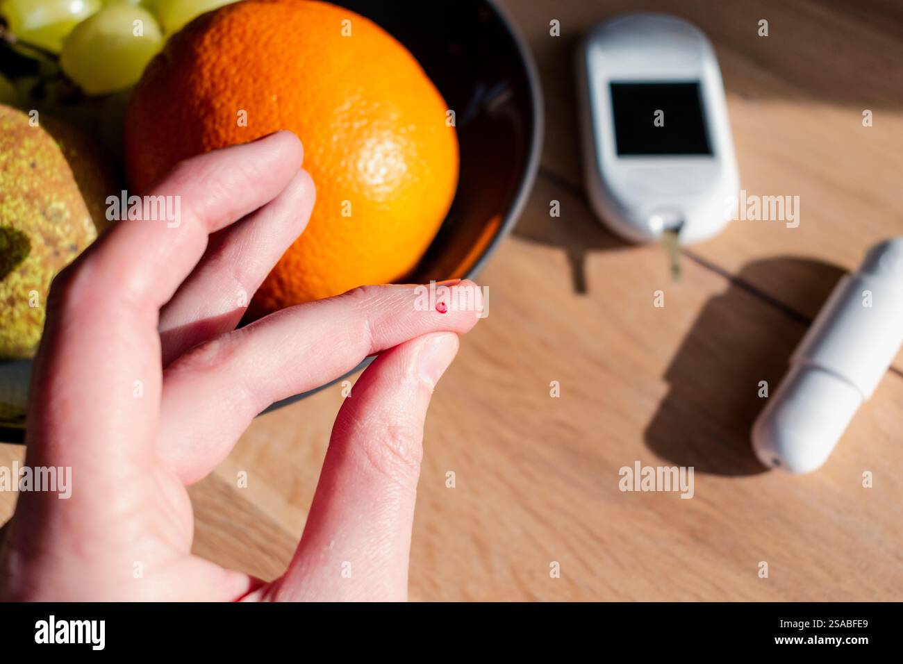 Woman pricking her finger to check blood glucose level with glucometer ...