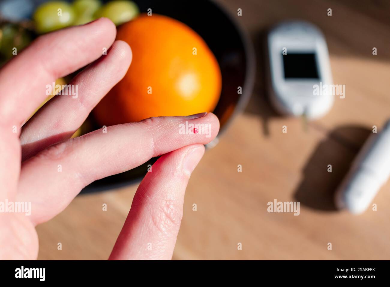 Woman pricking her finger to check blood glucose level with glucometer ...