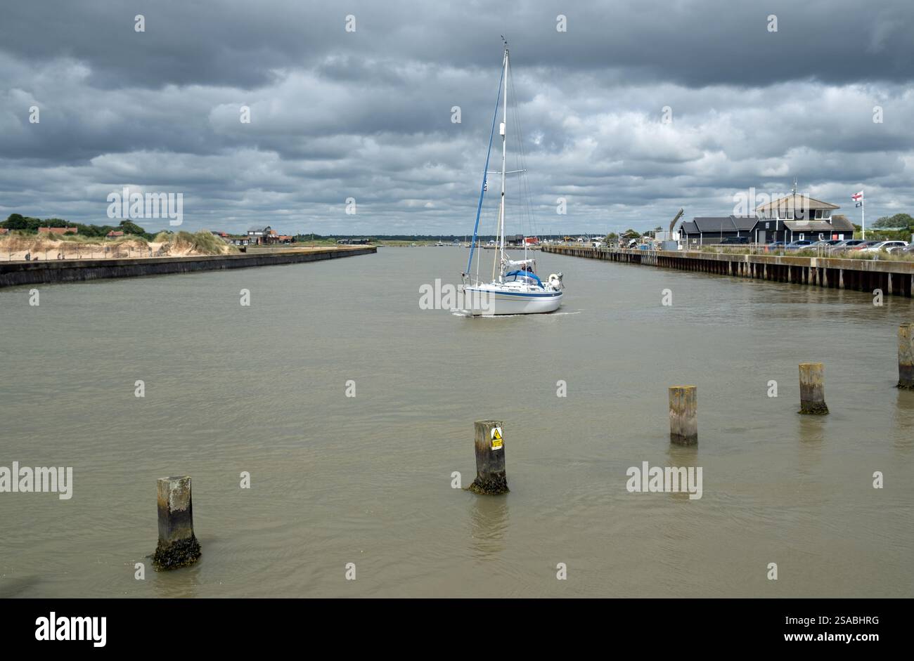 A yacht heading out to sea from the River Blyth estuary between ...