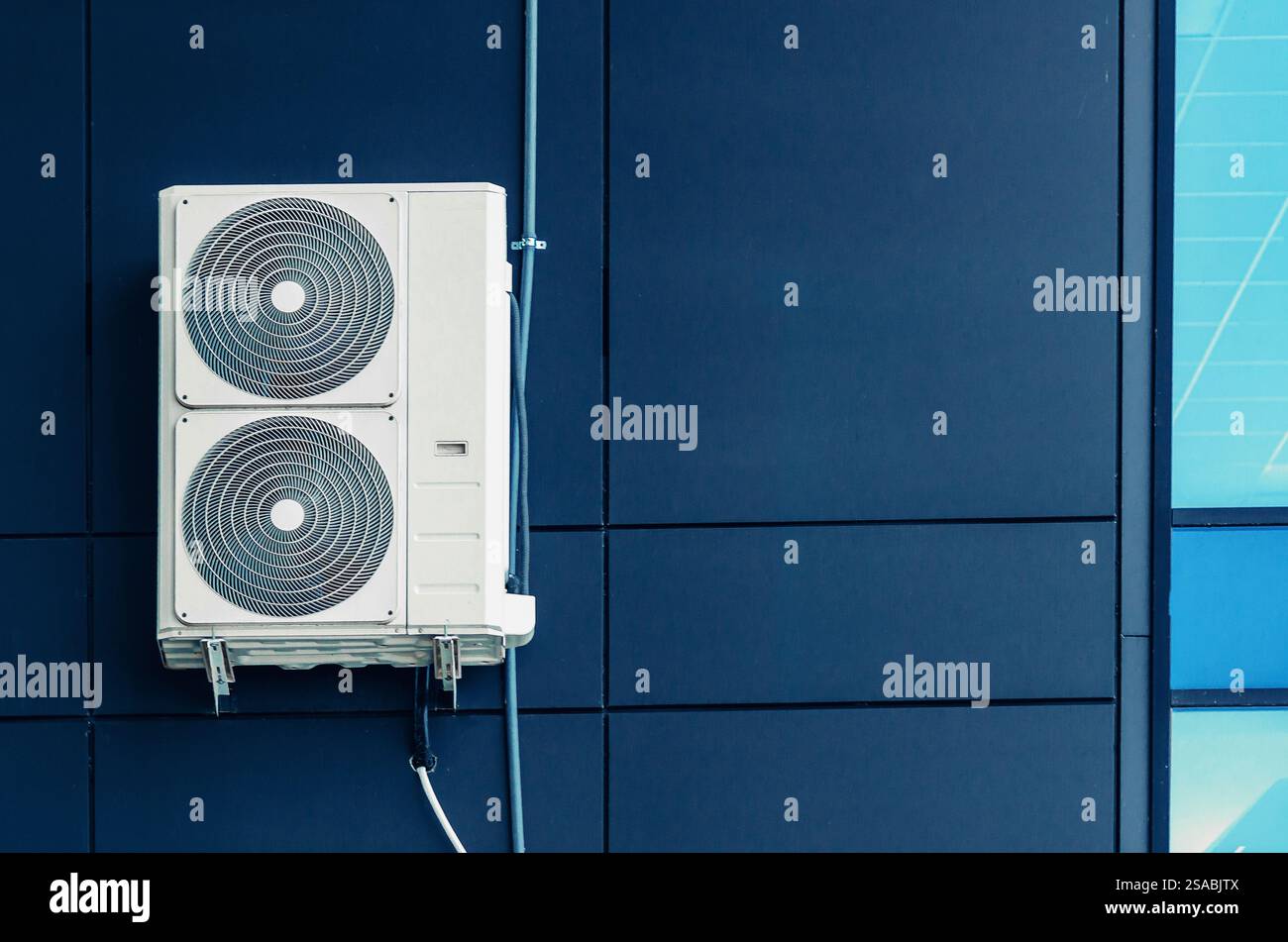 White air conditioner on the wall of a modern building. Ventilation of ...