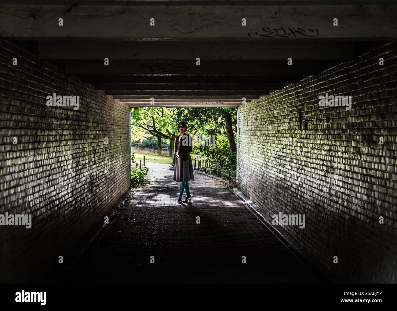 Outdoor portrait of a 31 yo woman in a dark tunnel, Laeken , Brussels ...