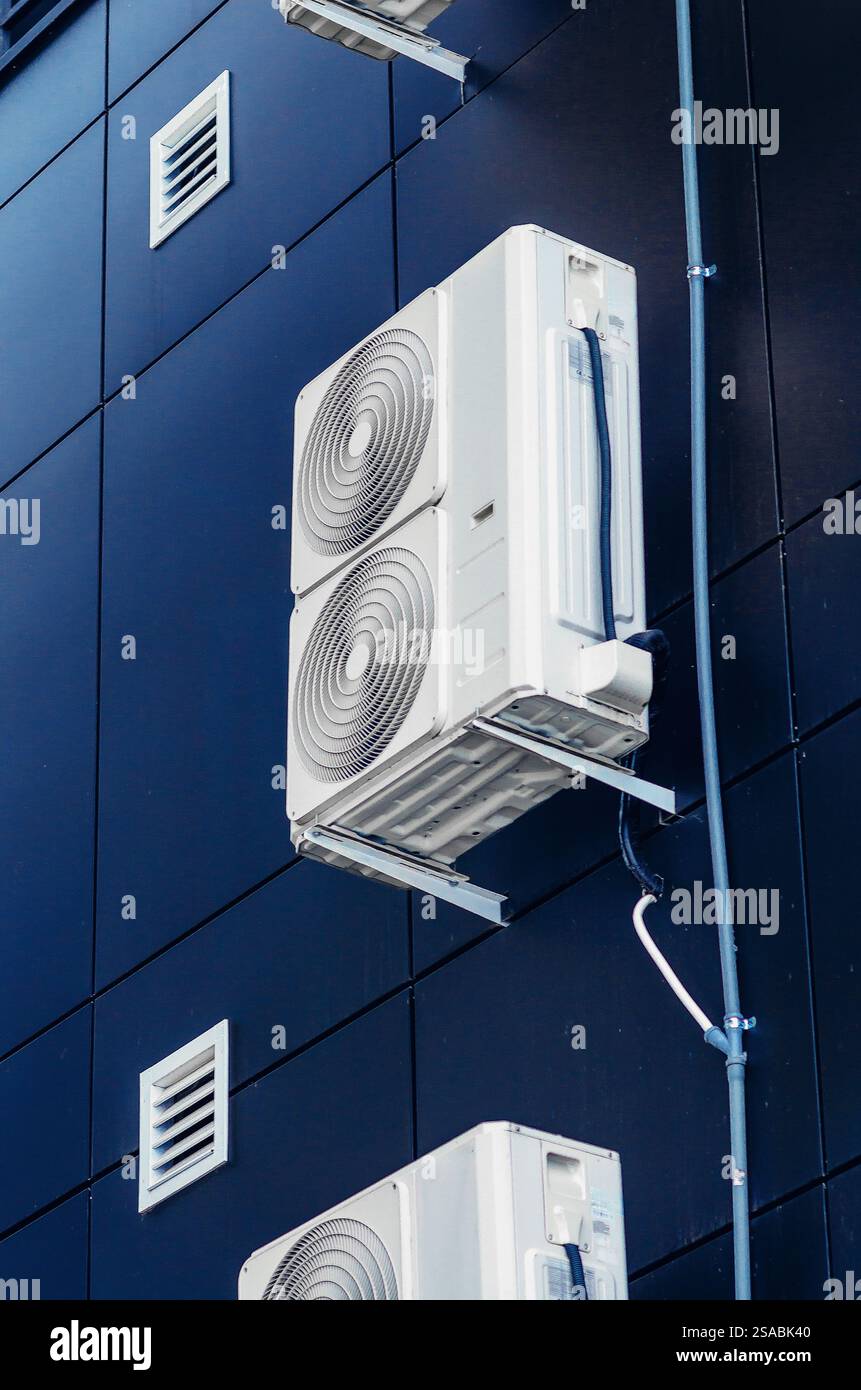 White air conditioner on the wall of a modern building. Ventilation of ...
