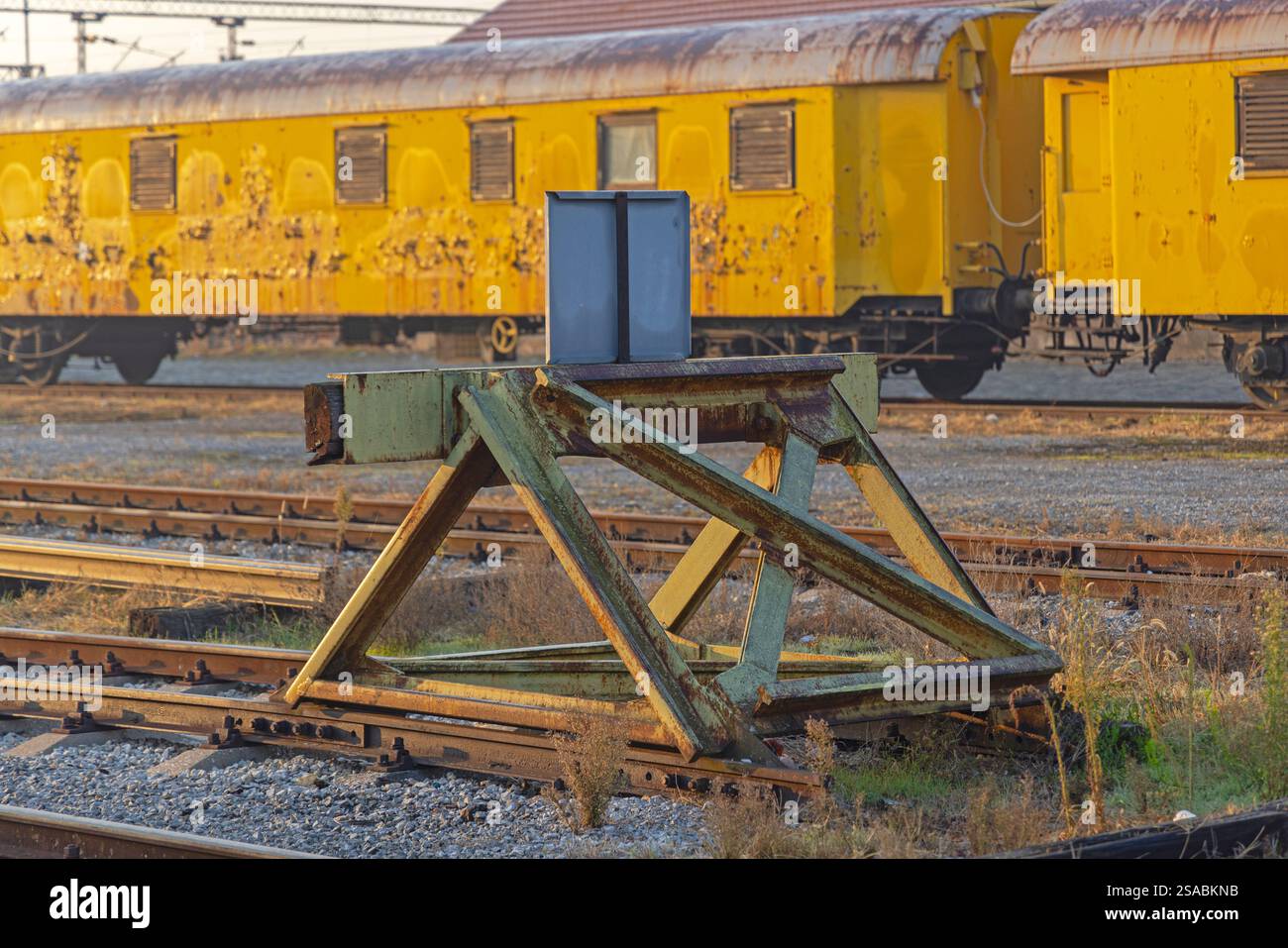 Railroad Buffer Stop Metal Bumper at Tracks and Old Yellow Train Wagon ...